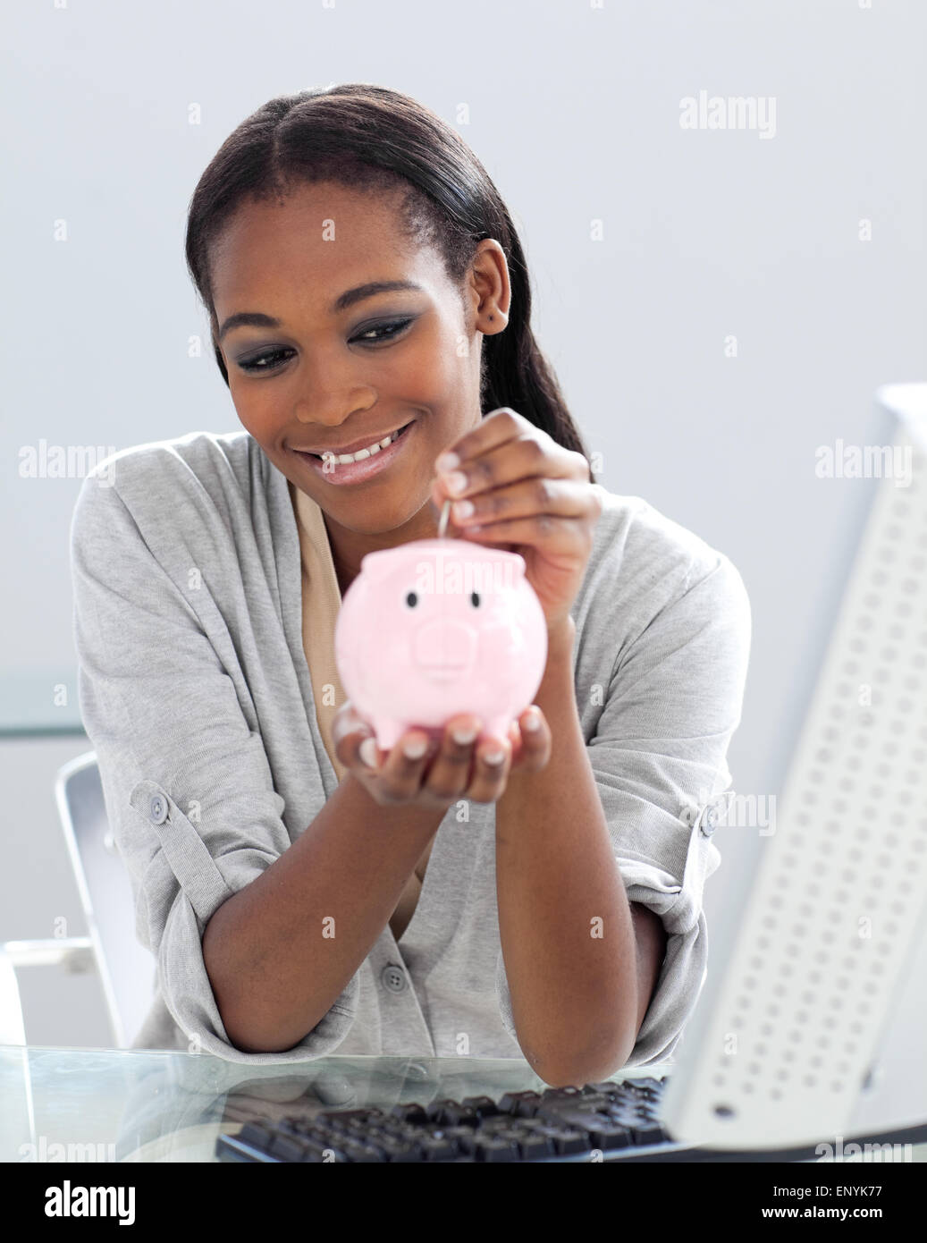 Assertive Afro-american businesswoman saving money in a piggybank Stock ...