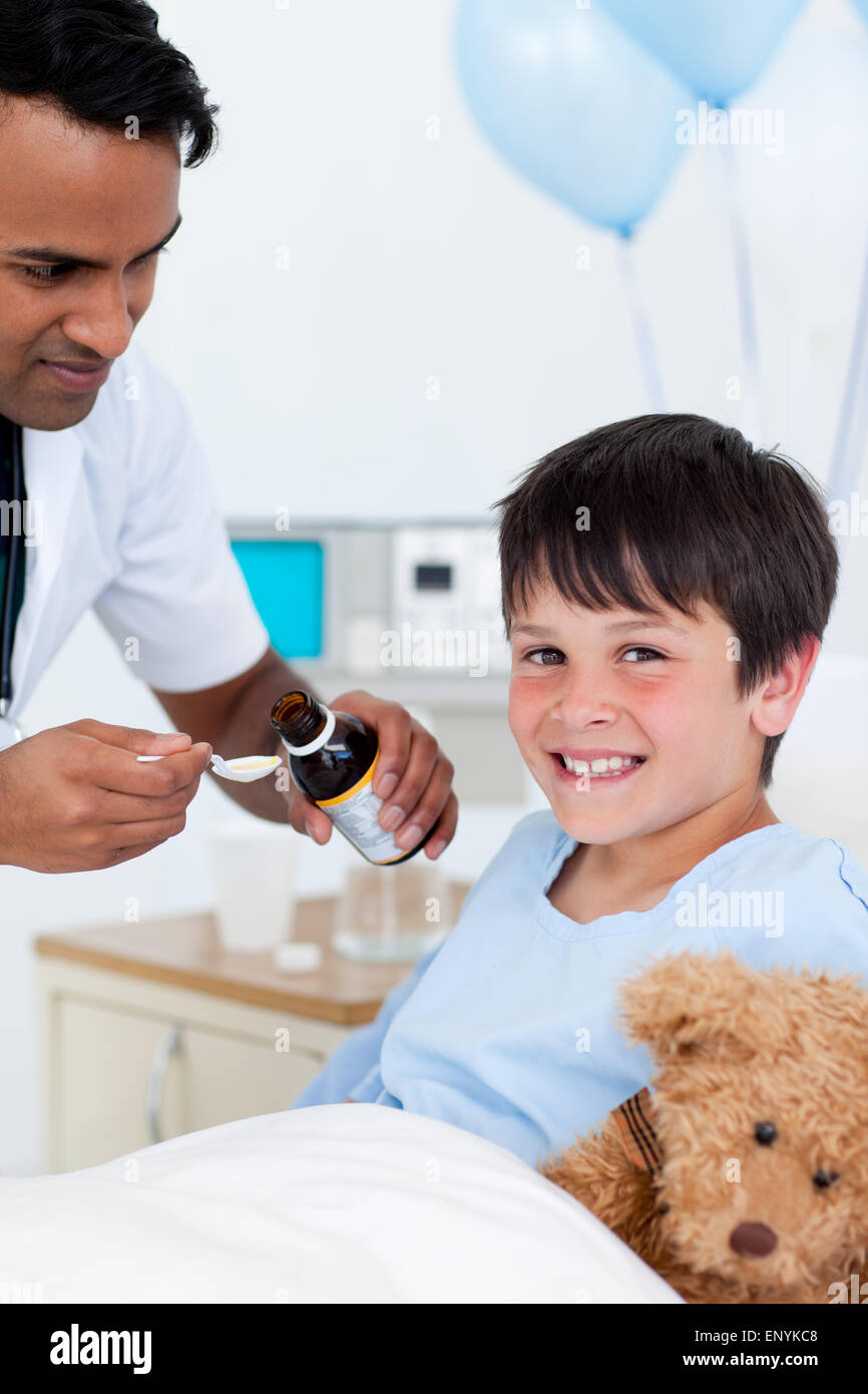 Positive doctor giving medicine to a little boy Stock Photo - Alamy