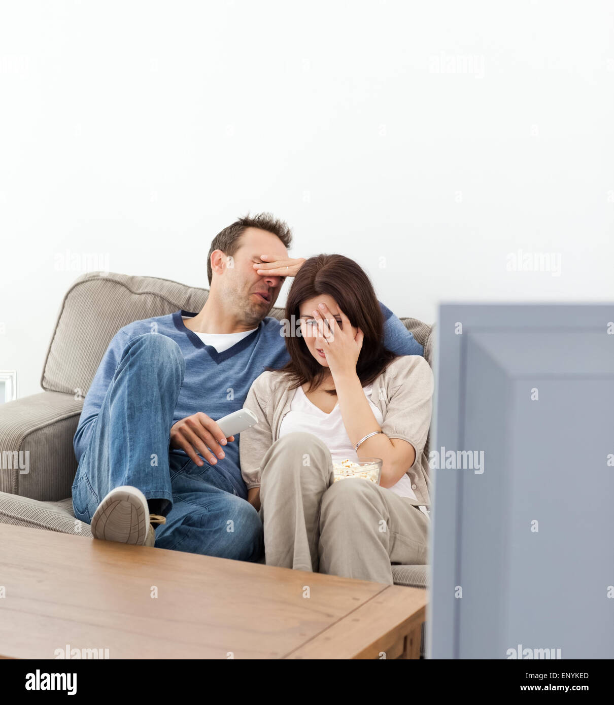 Scared couple hiding their faces while watching a horror movie Stock ...