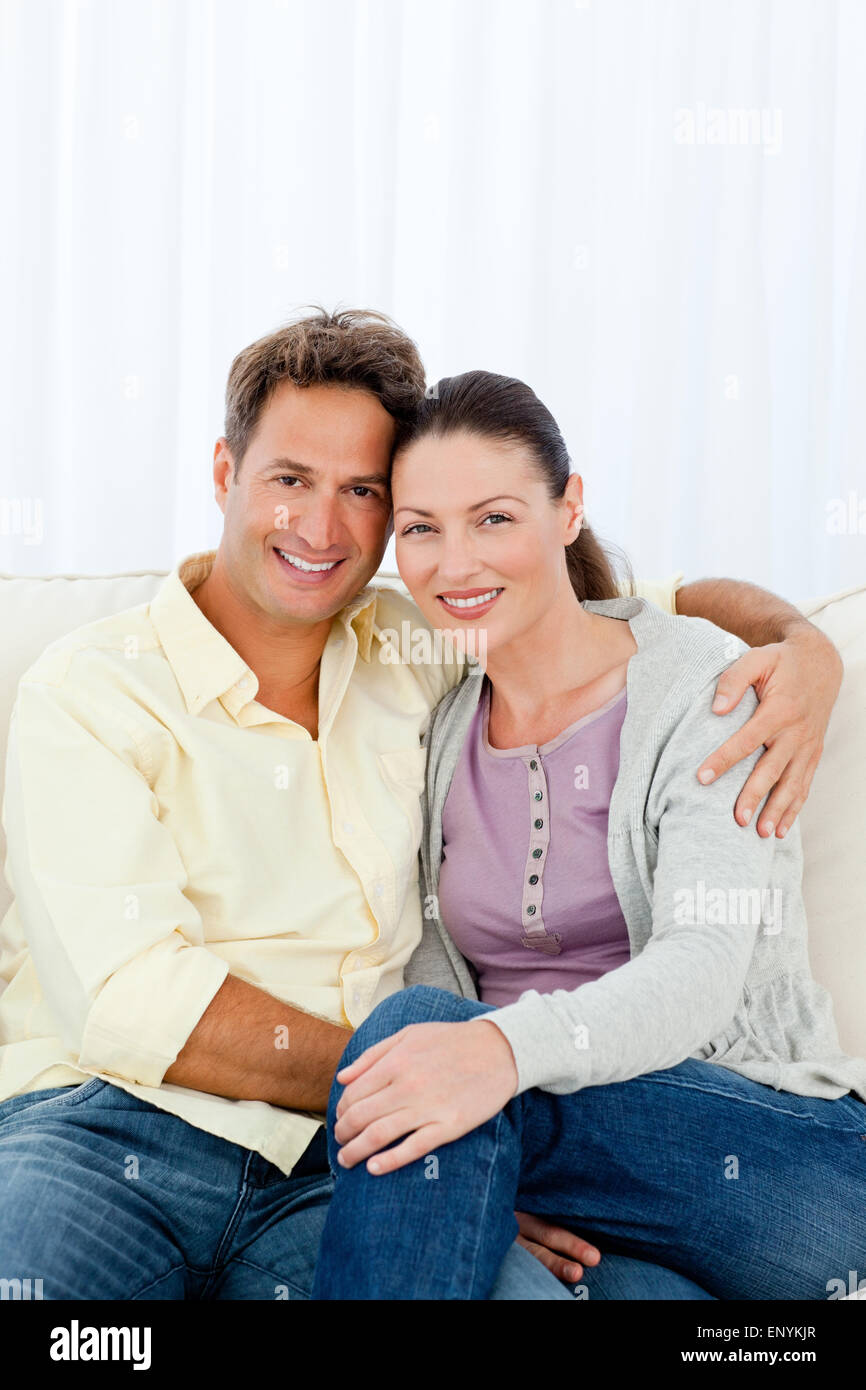 Lovely couple hugging sitting on the sofa Stock Photo - Alamy