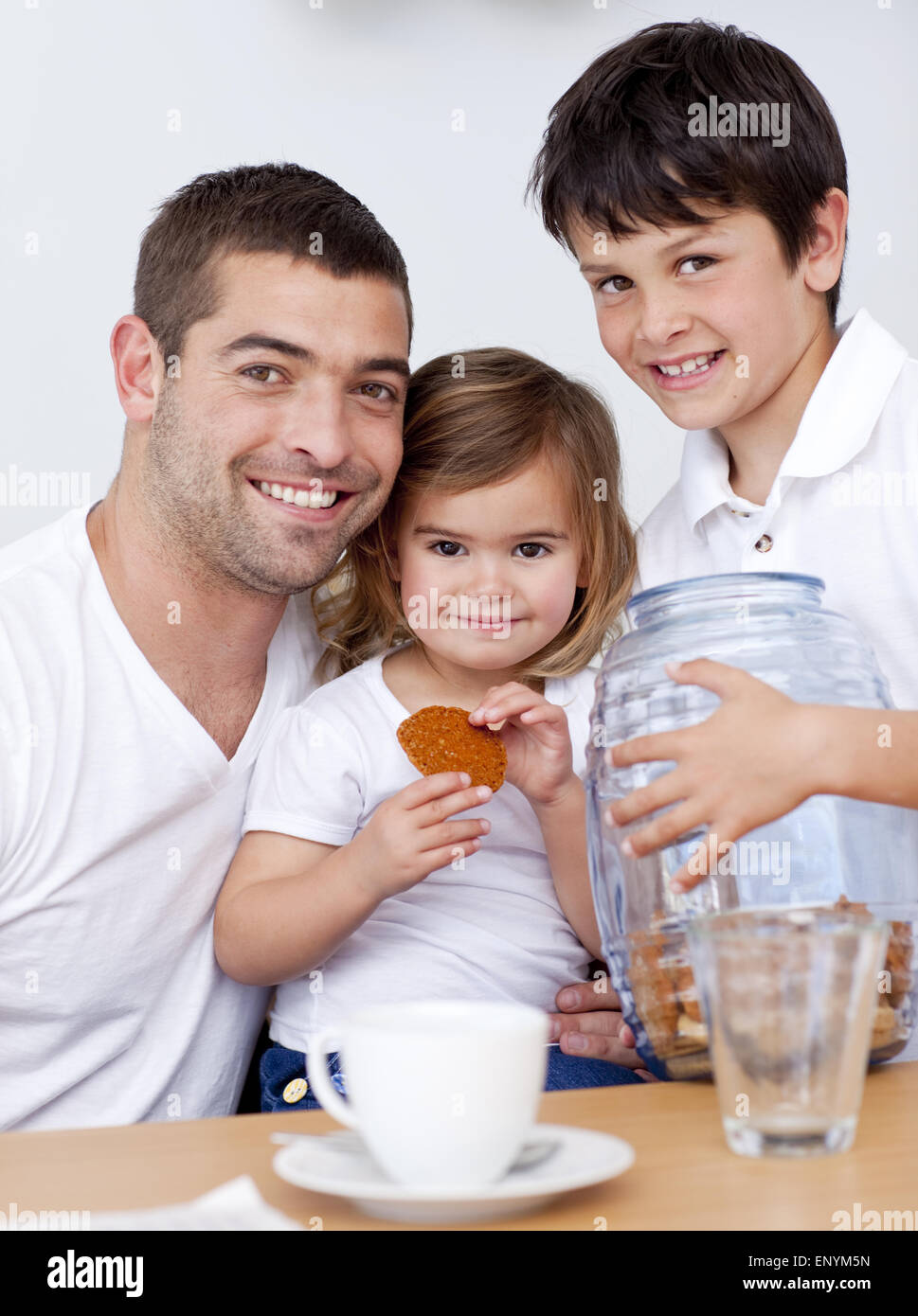 Father and children eating biscuits with milk Stock Photo - Alamy