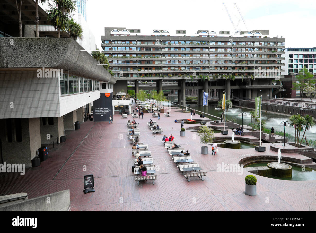 People sitting outside at tables on the forecourt of the Barbican ...