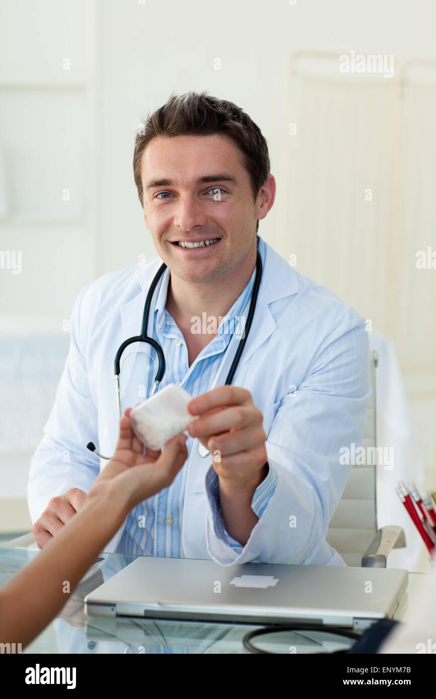 Smiling doctor giving pills to his patient Stock Photo - Alamy