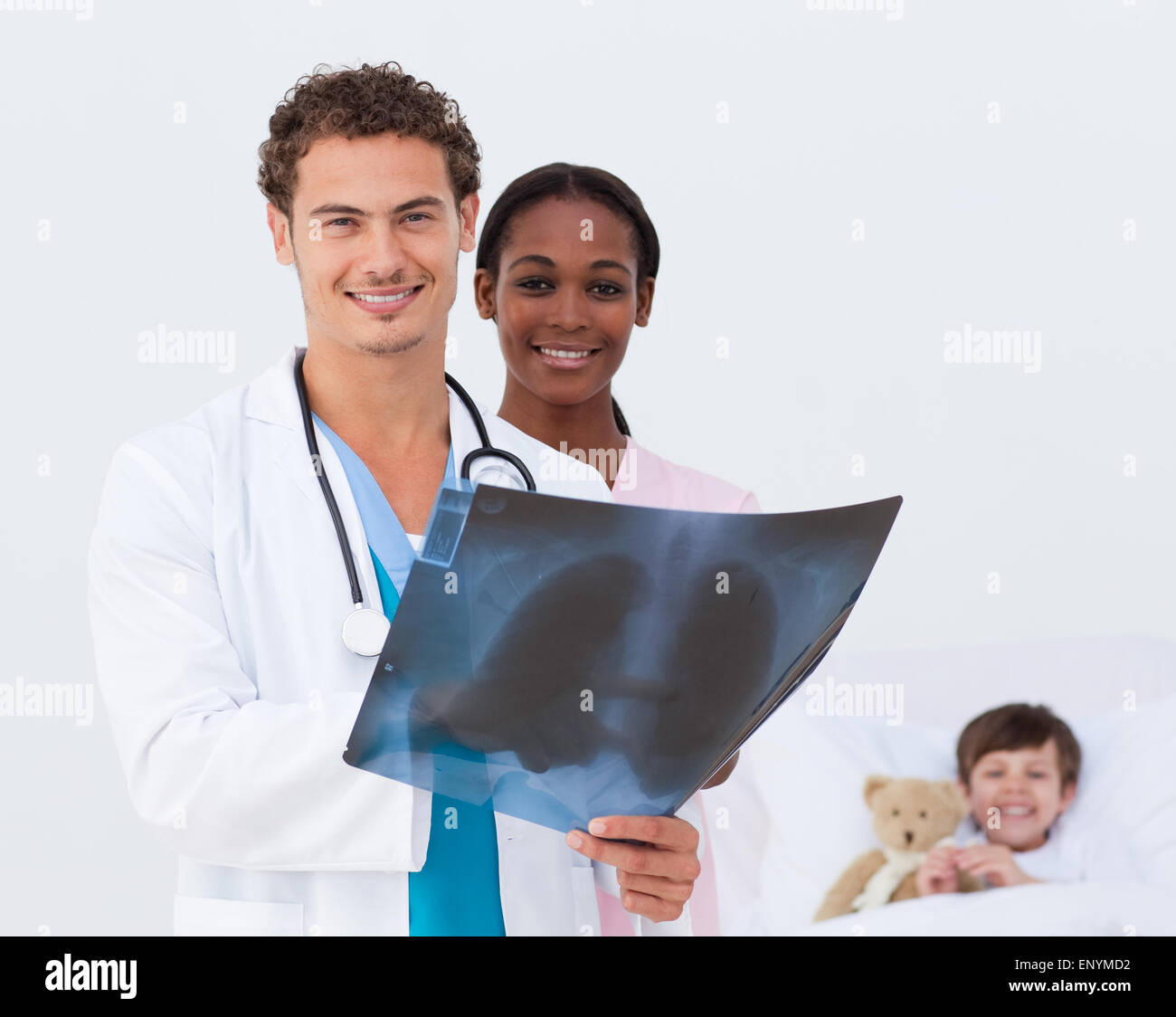 Smiling doctor and nurse examining an x-ray and a kid in bed Stock ...