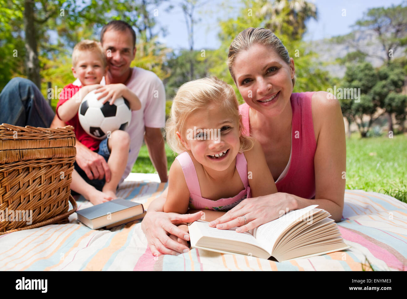 Mother and her daughter reading lying on a picnic tablecloth Stock ...