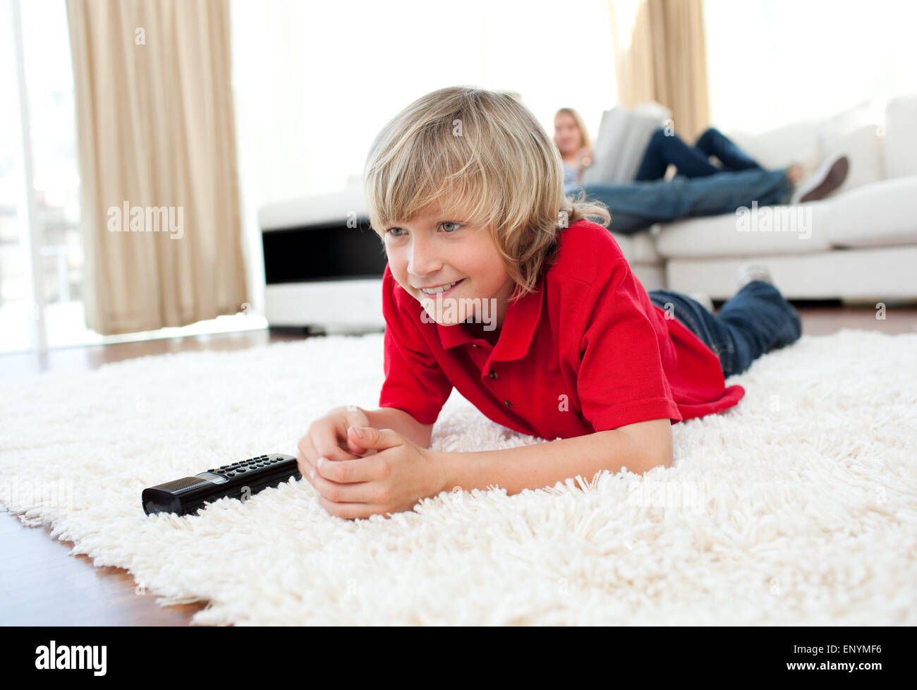 Concentrated boy watching TV lying on the floor Stock Photo - Alamy