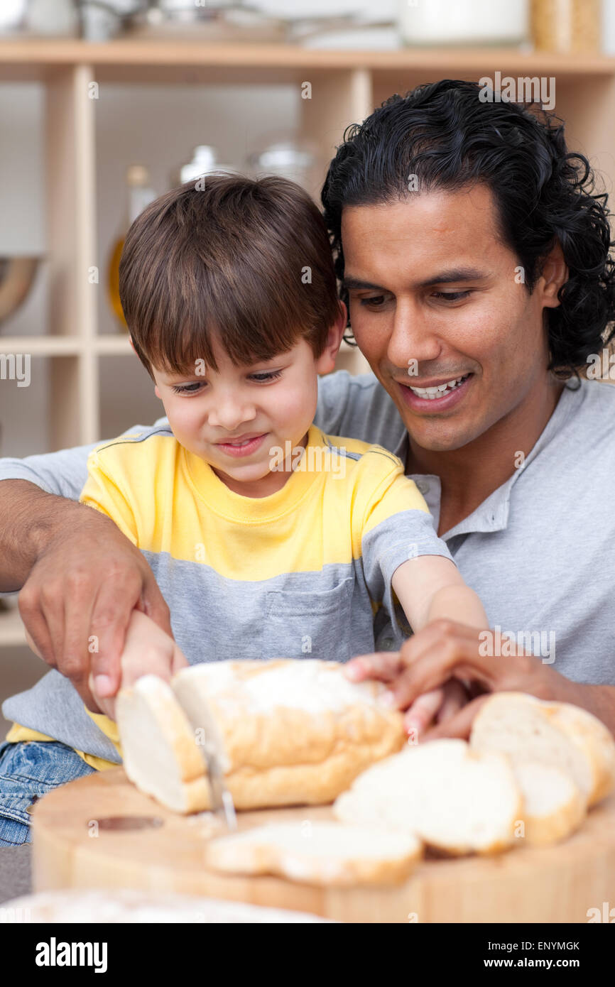Attractive father helping his son cut some bread Stock Photo - Alamy