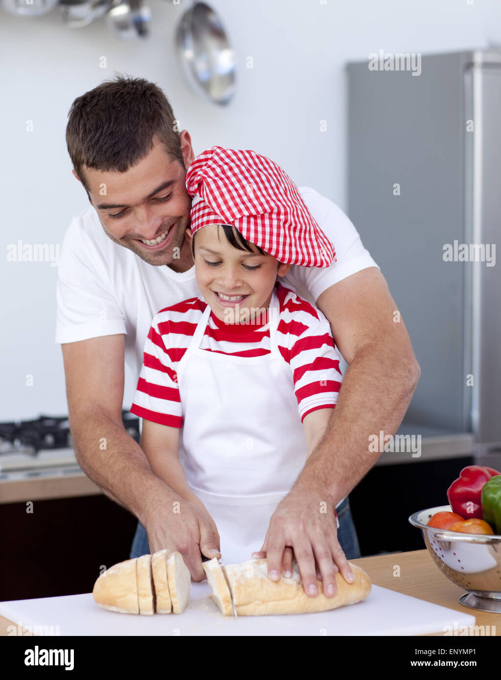 Man and little boy cutting bread Stock Photo - Alamy