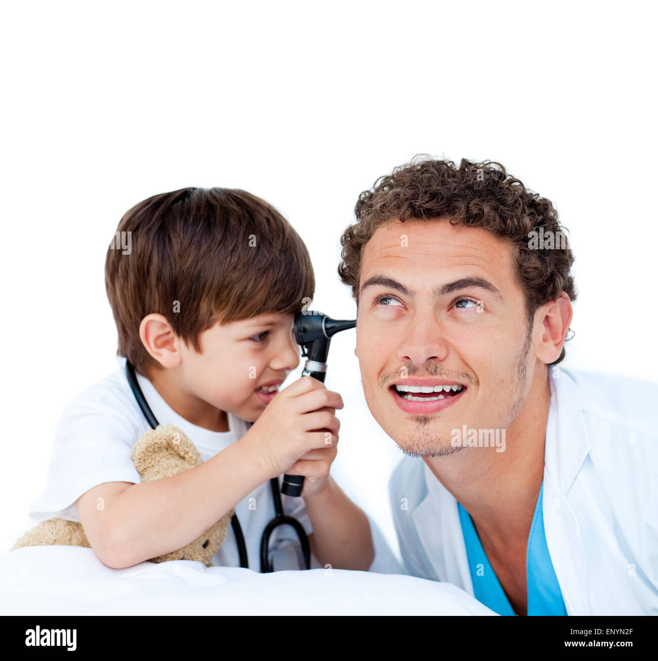 Smiling little boy playing with the doctor against a white background ...