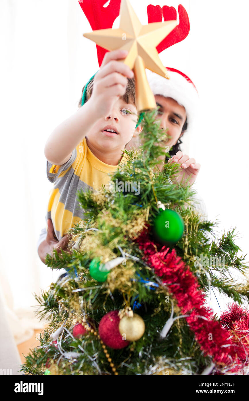Father and son putting a star on the top of a Christmas tree Stock ...