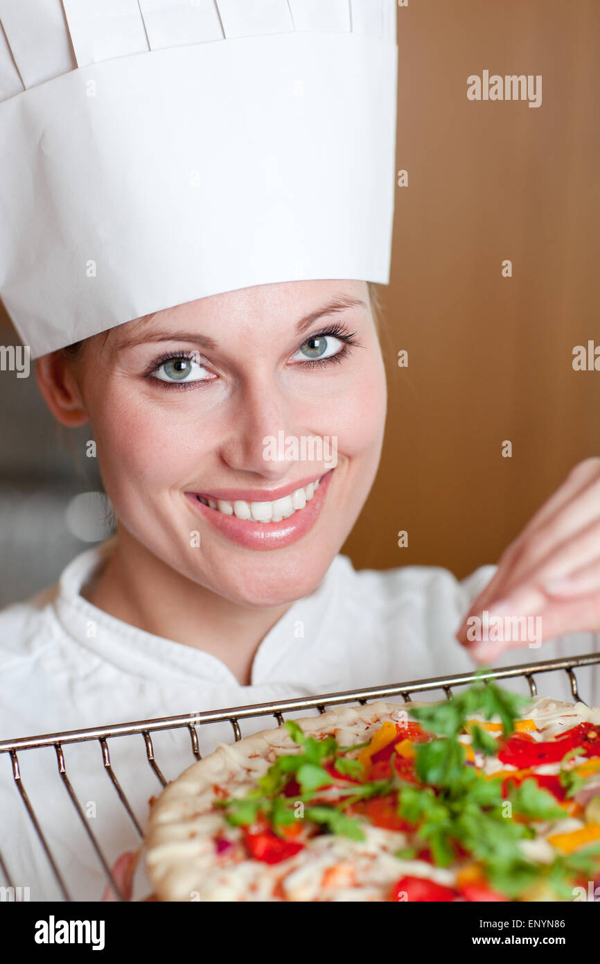 Radiant female chef cooking a pizza Stock Photo - Alamy