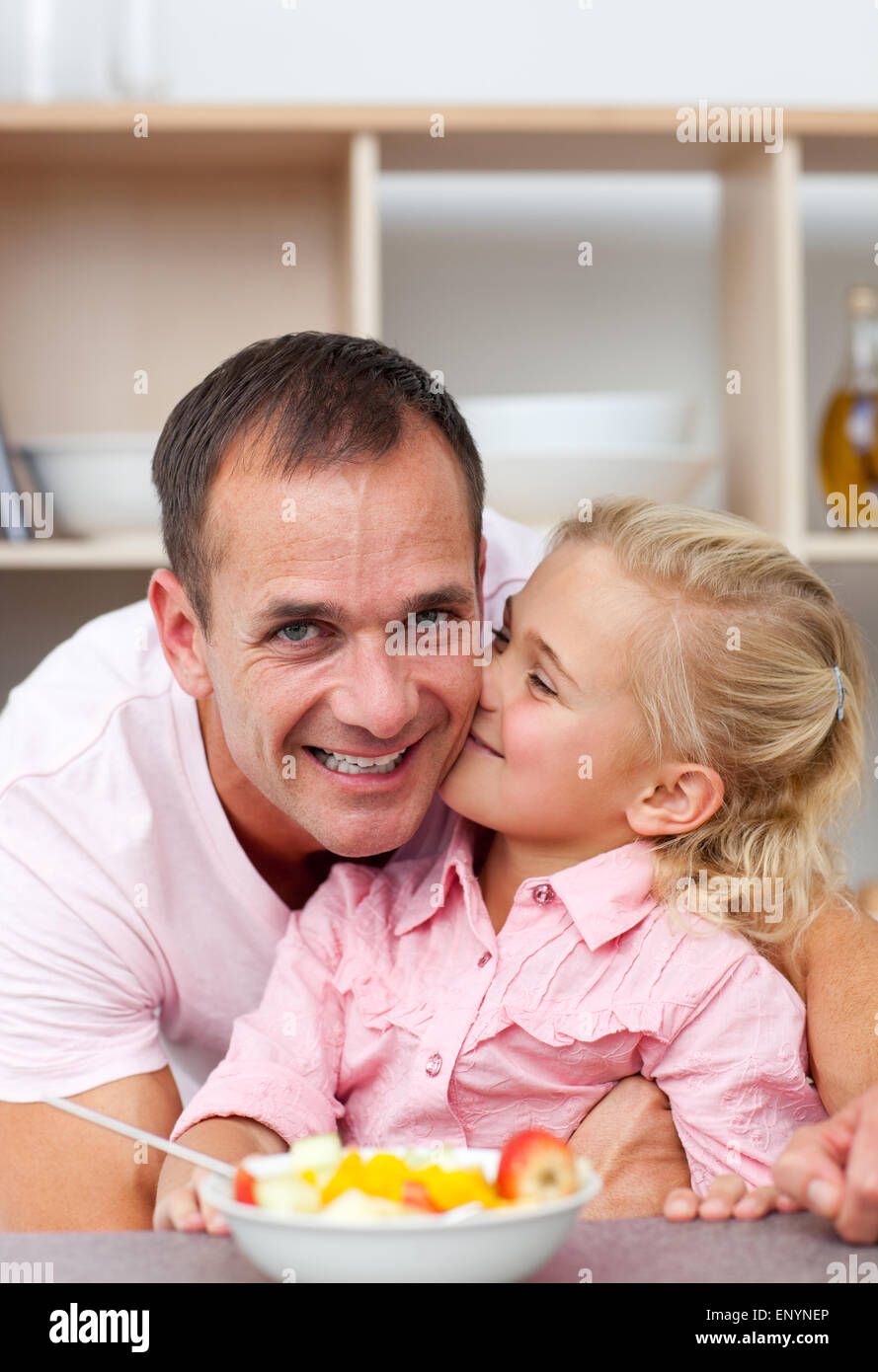 Attentive father eating fruit with his daughter Stock Photo - Alamy