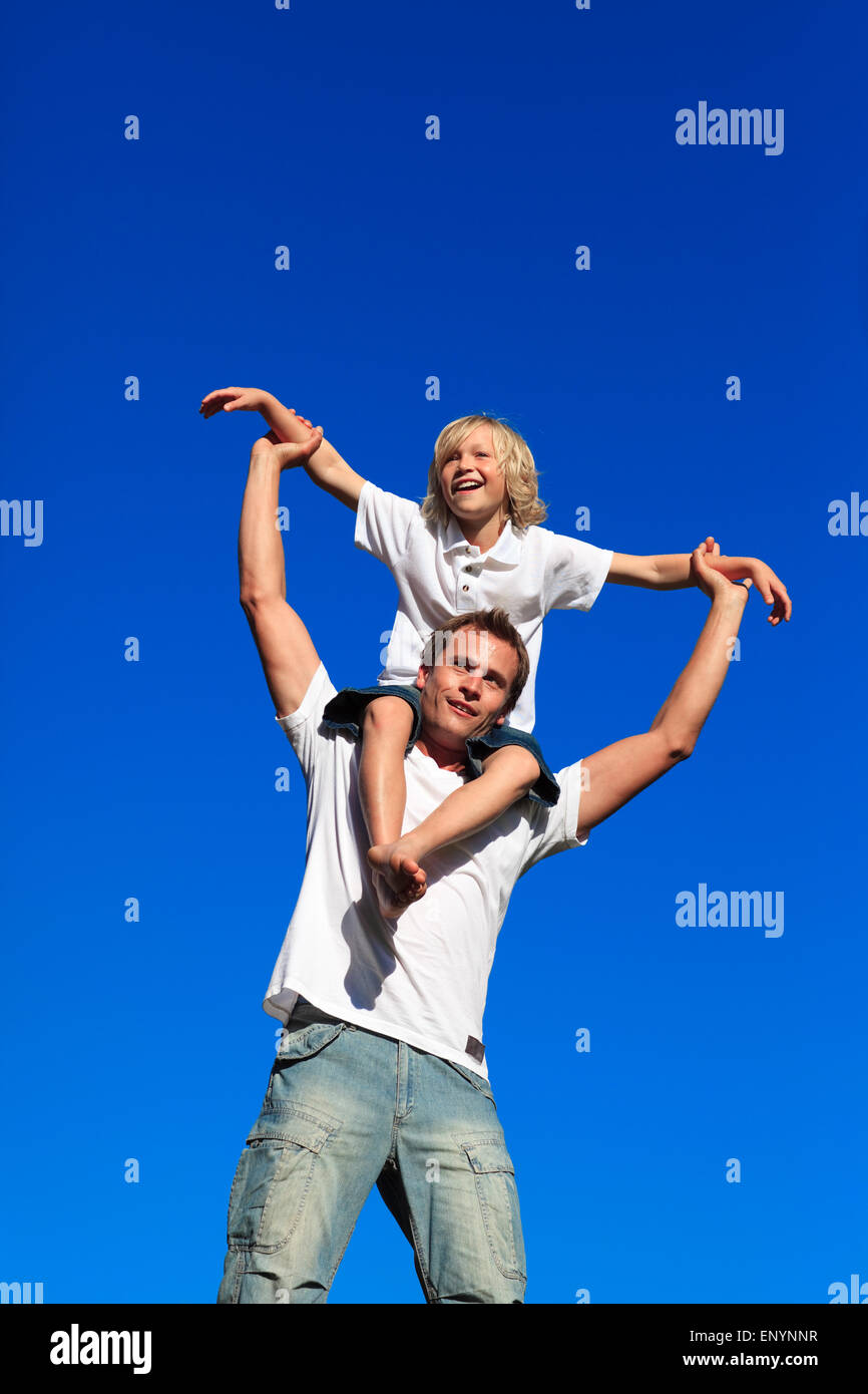 Man giving young boy piggyback ride smiling Stock Photo - Alamy