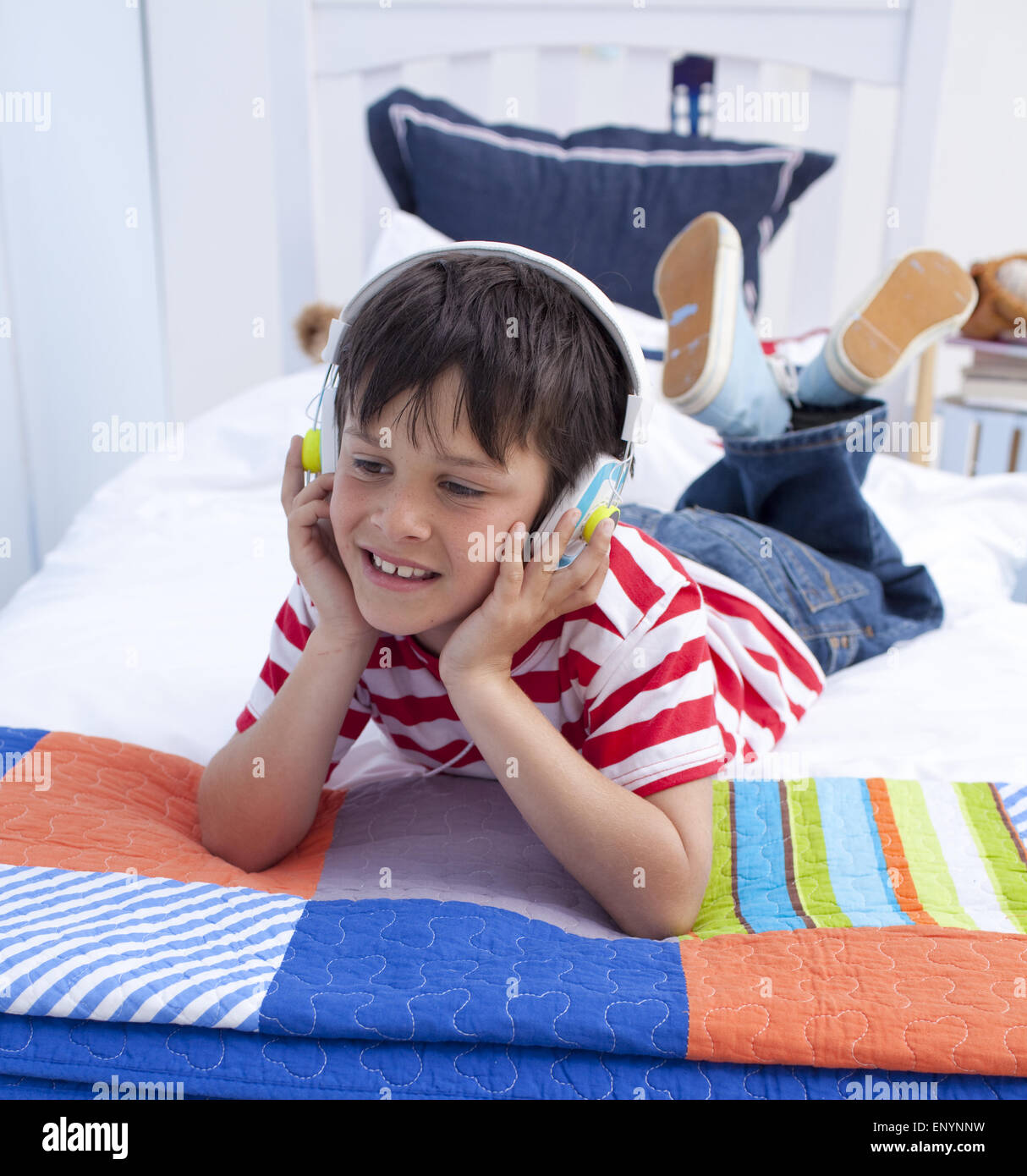 Boy relaxing in bed listening to music Stock Photo - Alamy