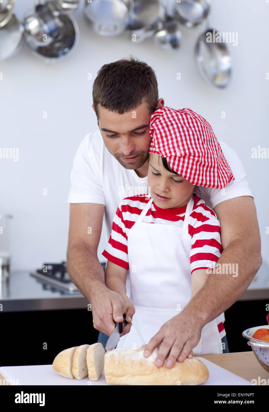 Father helping his son cutting bread Stock Photo - Alamy