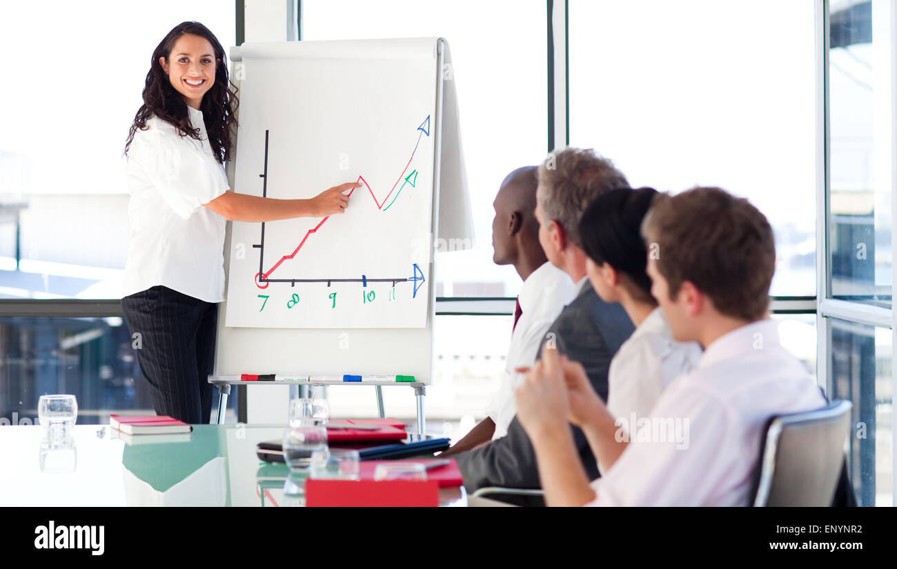 Businesswoman explaining a graph looking at the camera Stock Photo - Alamy