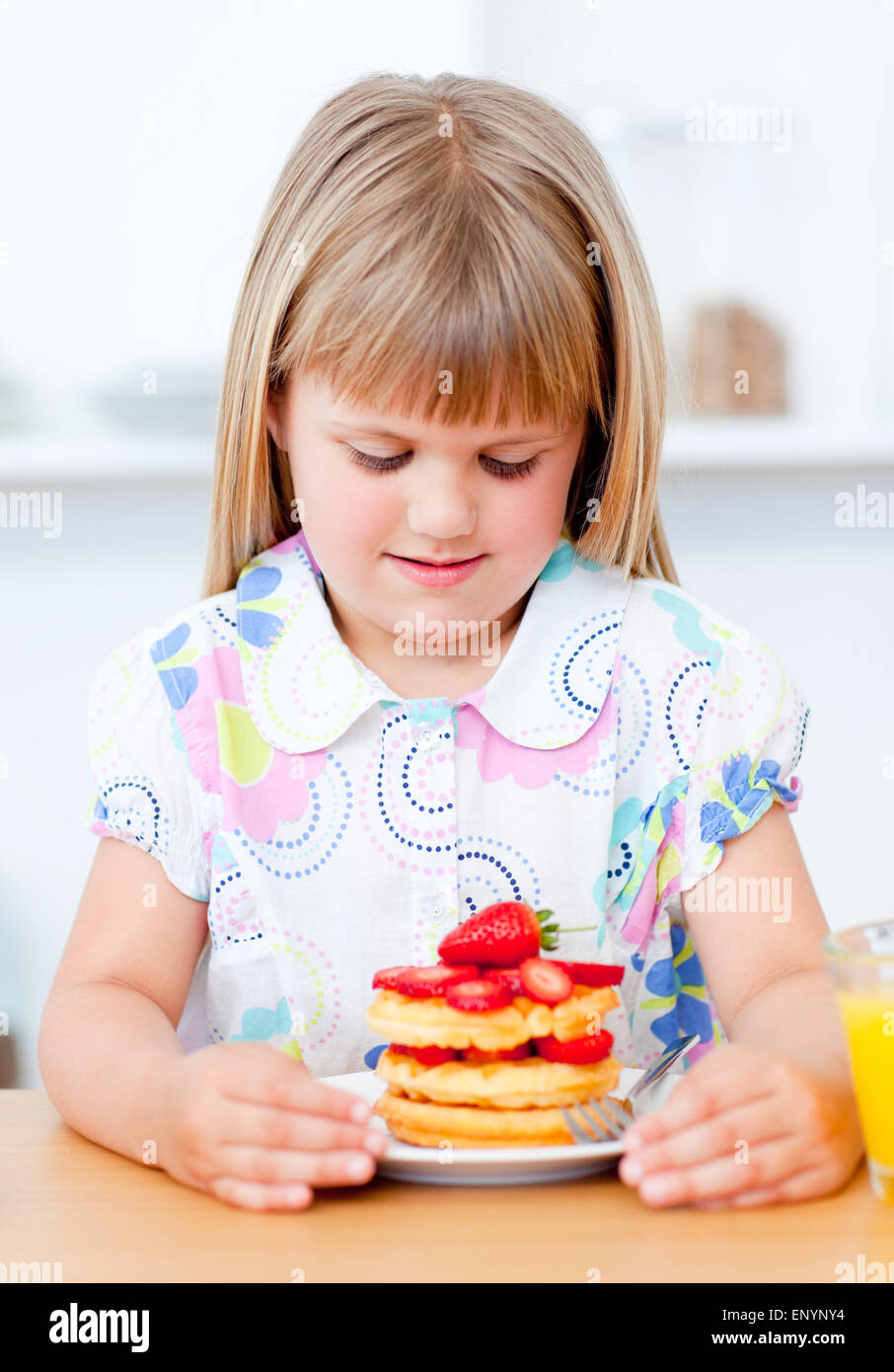 Adorable little girl eating waffles with strawberries Stock Photo - Alamy
