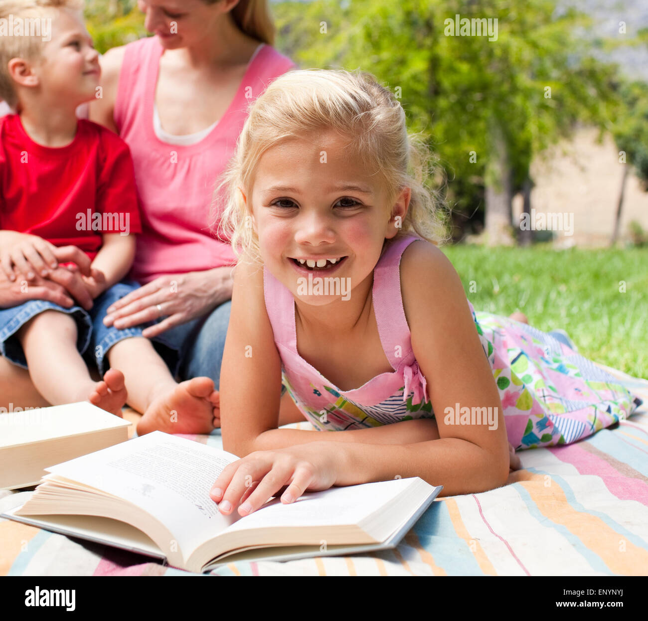 Close-up of a little girl reading at a picnic Stock Photo - Alamy