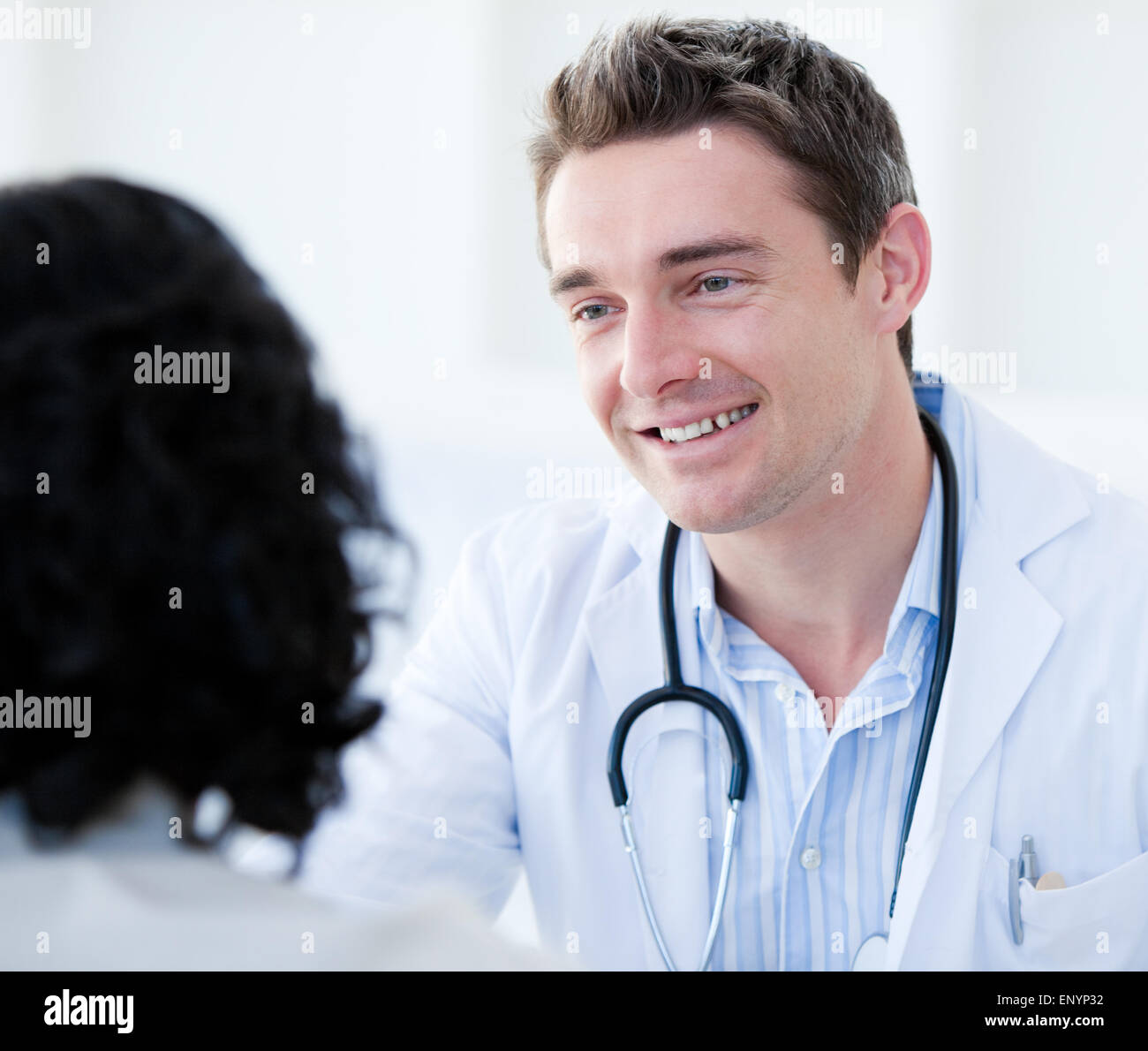 Portrait of a handsome doctor talking with his patient for the annual ...