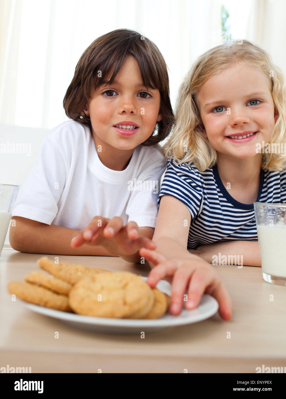 Cute siblings eating biscuits Stock Photo - Alamy