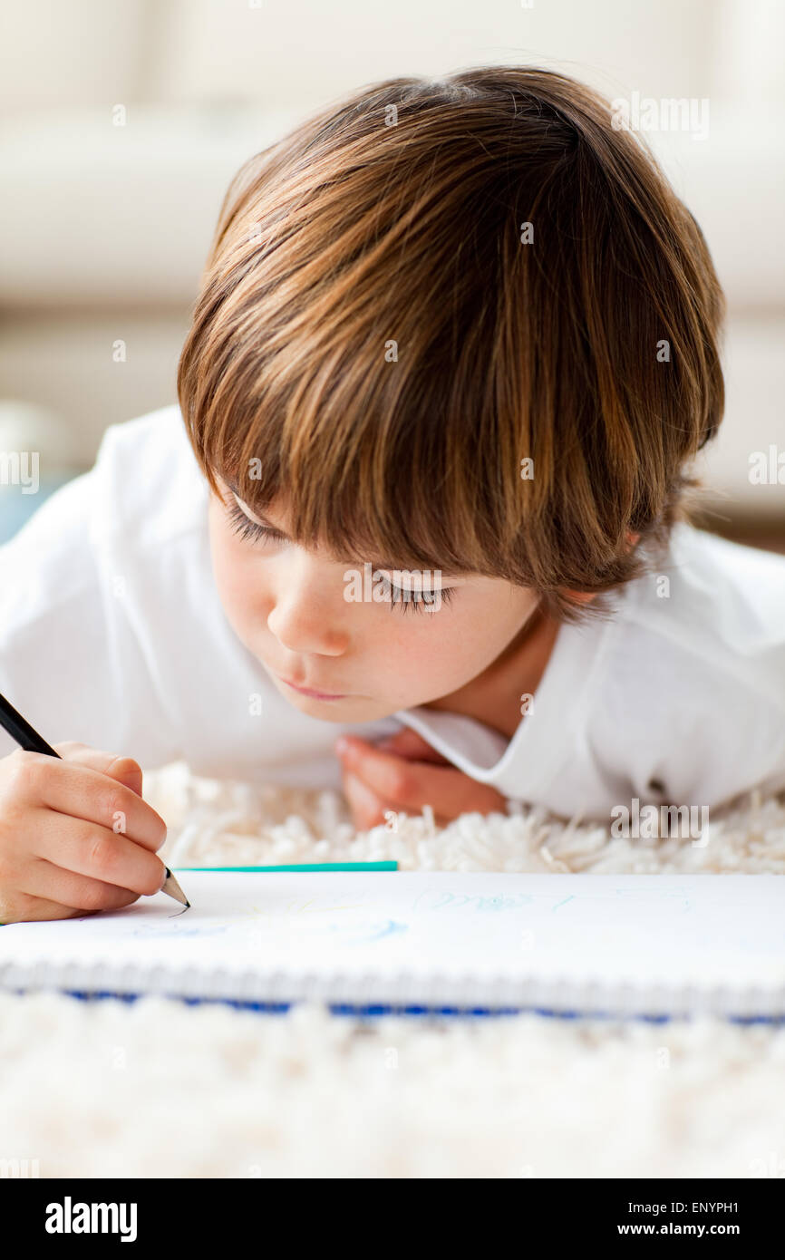 Serious little boy drawing lying on the floor Stock Photo - Alamy