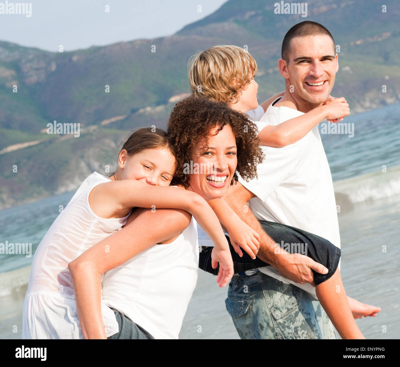 Parents giving two young children piggyback rides Stock Photo - Alamy