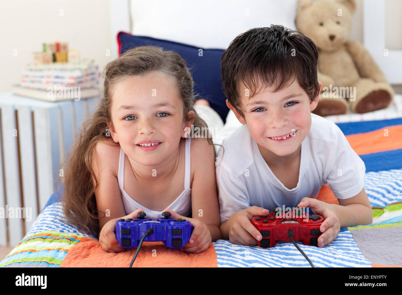 Siblings playing video games together Stock Photo - Alamy