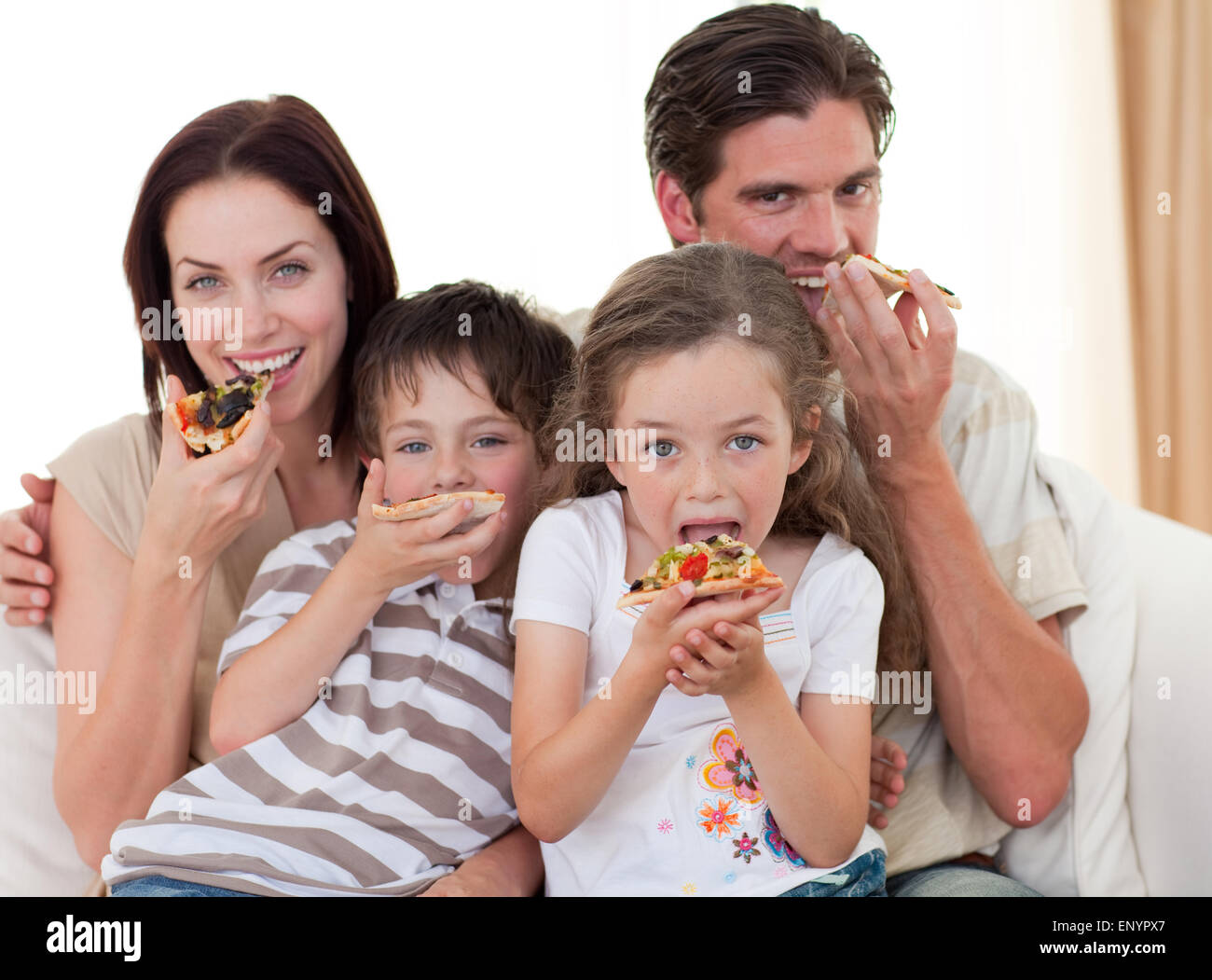 Happy family eating pizza Stock Photo - Alamy