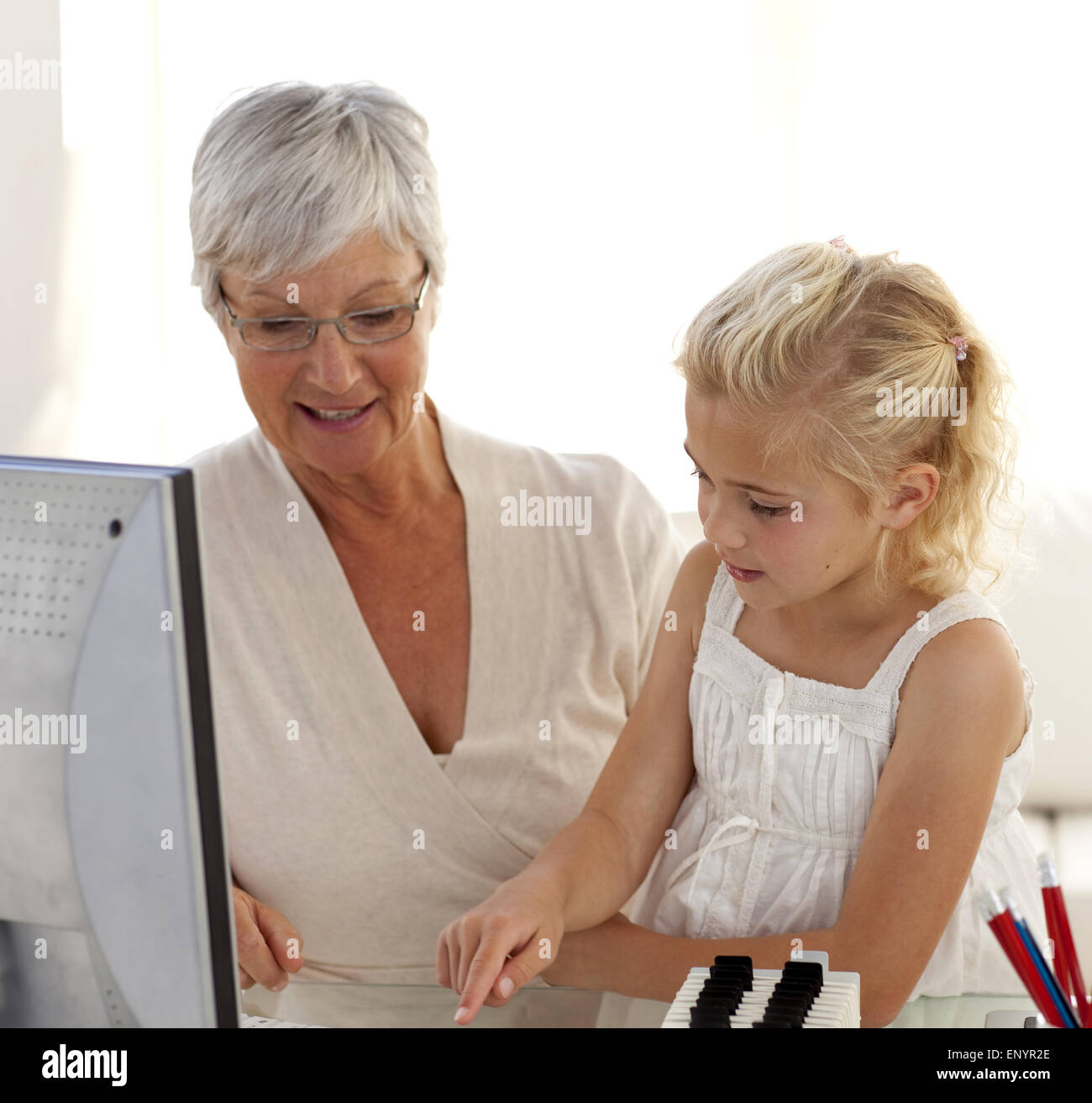 Little girl explaining her grandmother how to use a computer Stock ...