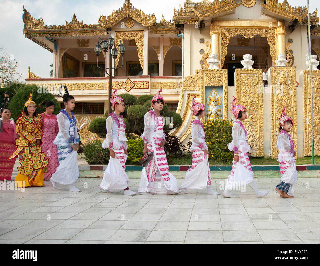 Group of Burmese children dressed in traditional costume walk in line ...