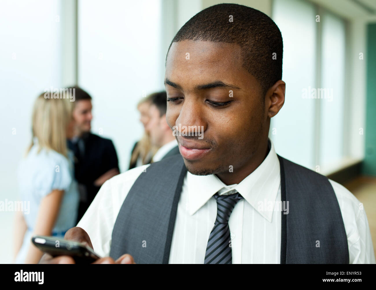 Afro-American businessman texting in office Stock Photo - Alamy