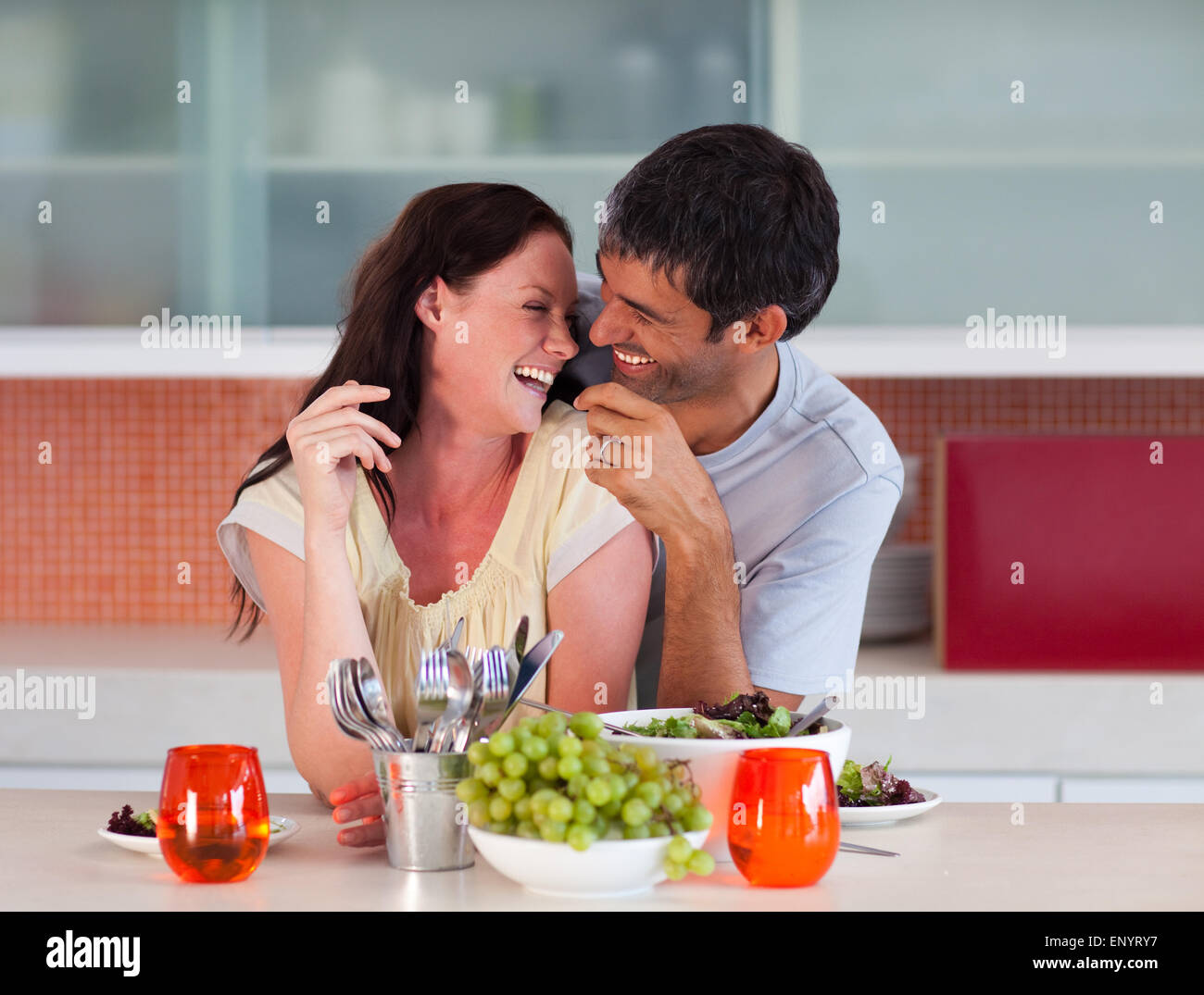 Lovers eating in the kitchen Stock Photo - Alamy