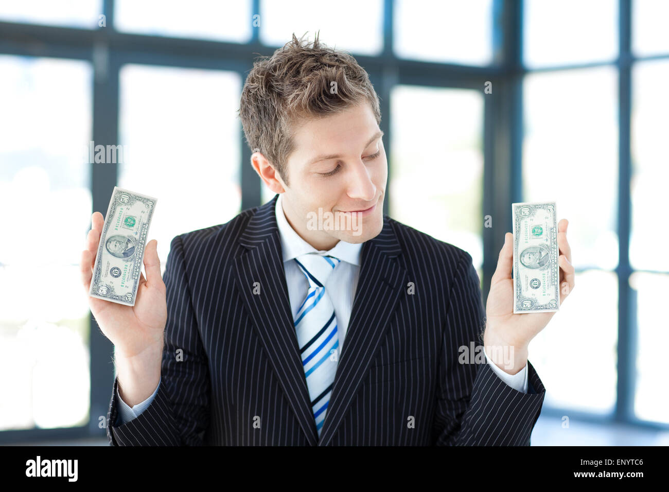 Smiling businessman holding money Stock Photo - Alamy