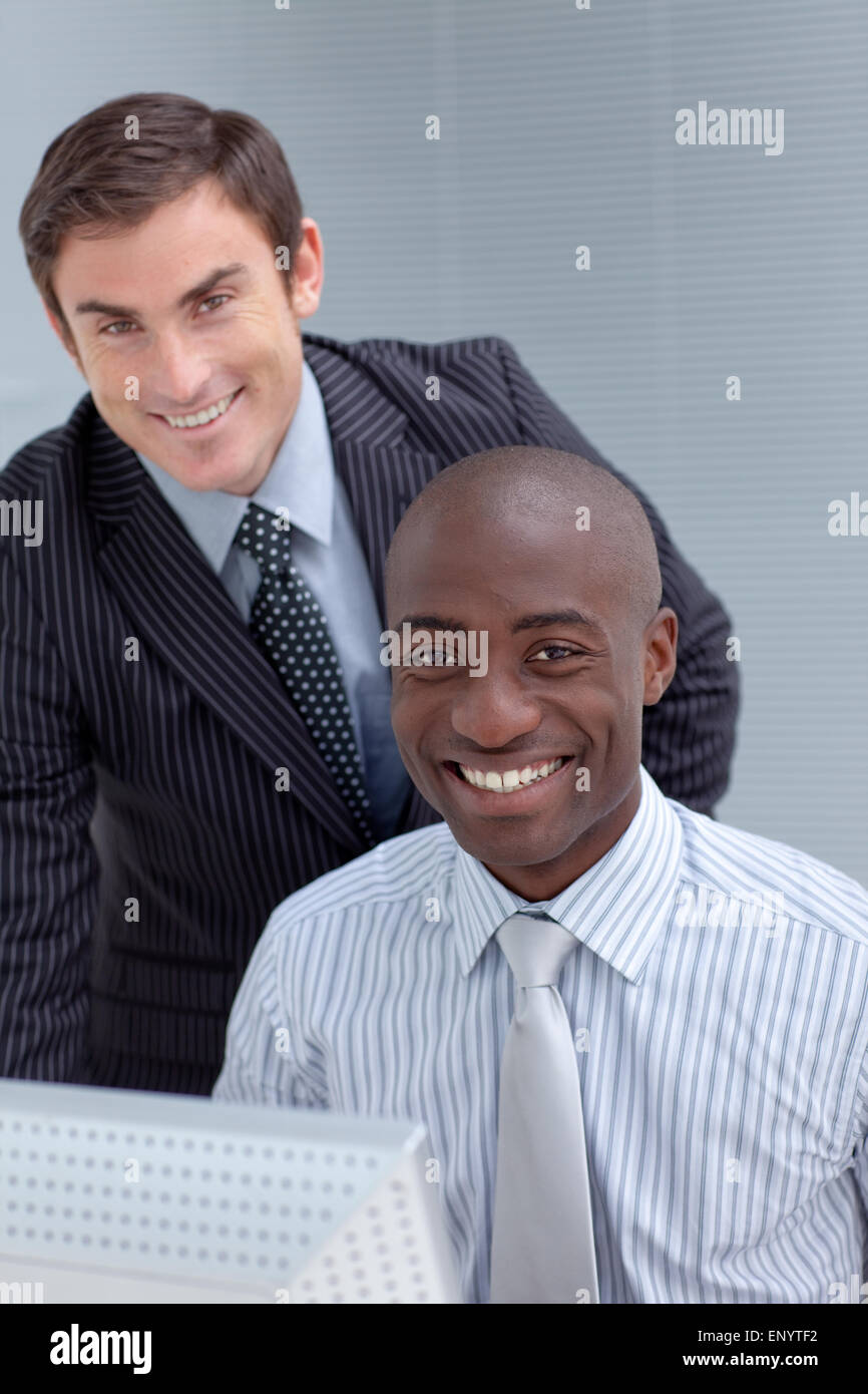 Smiling businessmen using a computer together in office Stock Photo - Alamy