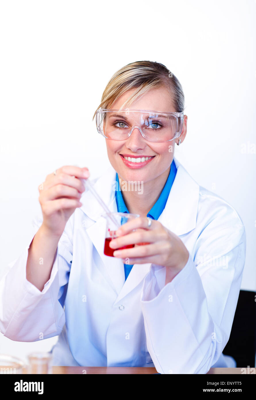 Female scientist examining a test-tube and smiling at the camera Stock ...