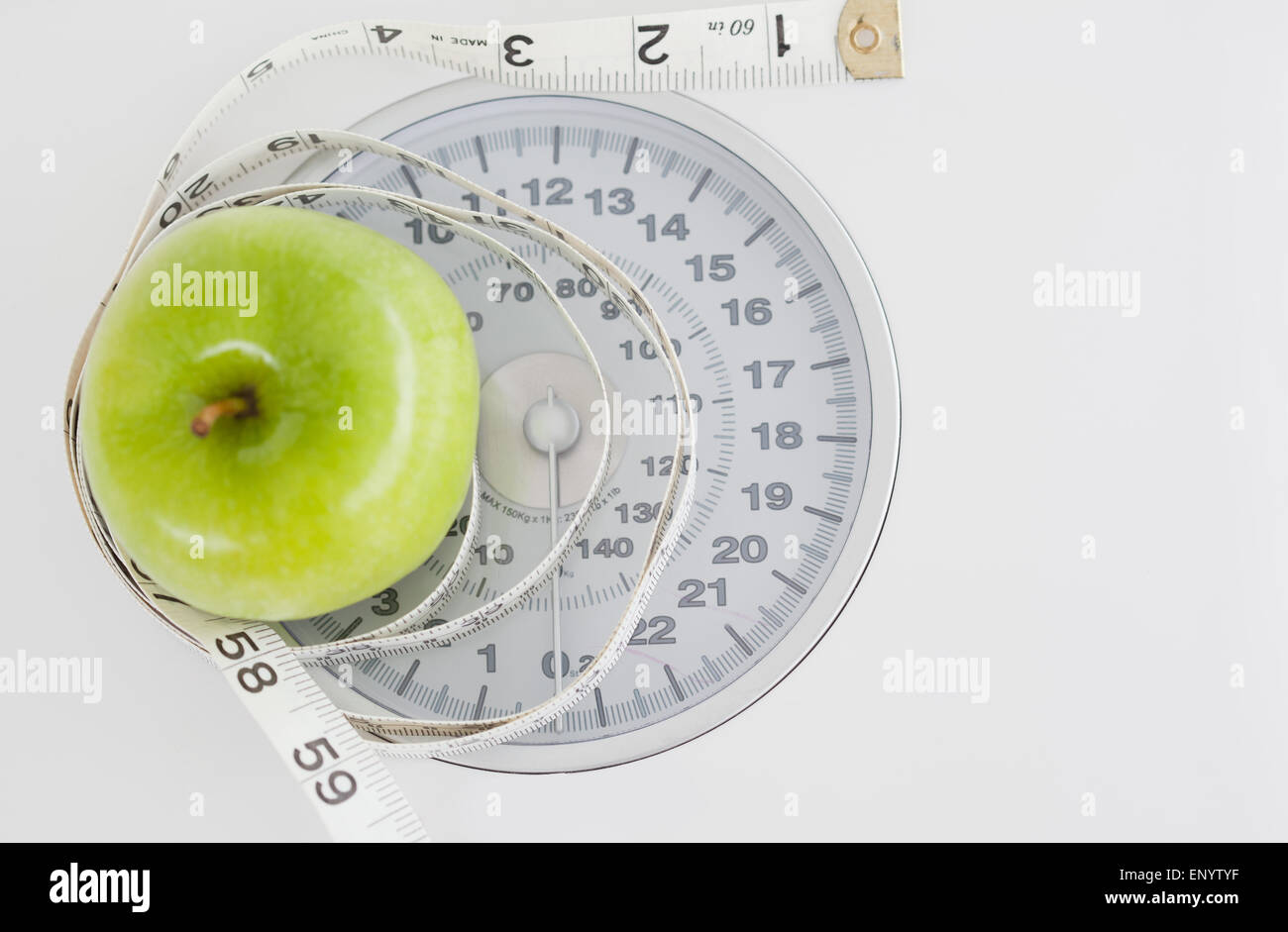 Green apple circled with a tape measure and weigh-scale Stock Photo - Alamy