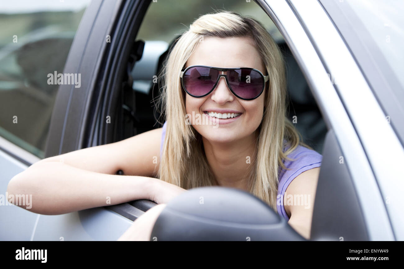 Jolly female driver wearing sunglasses sitting in her car Stock Photo ...