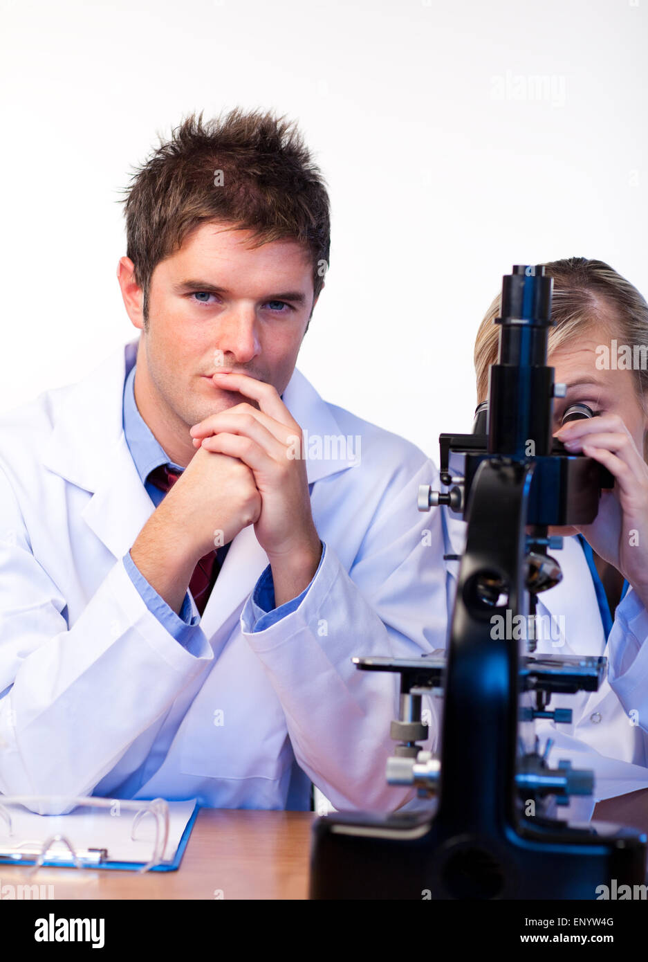 Scientists looking through a microscope Stock Photo - Alamy