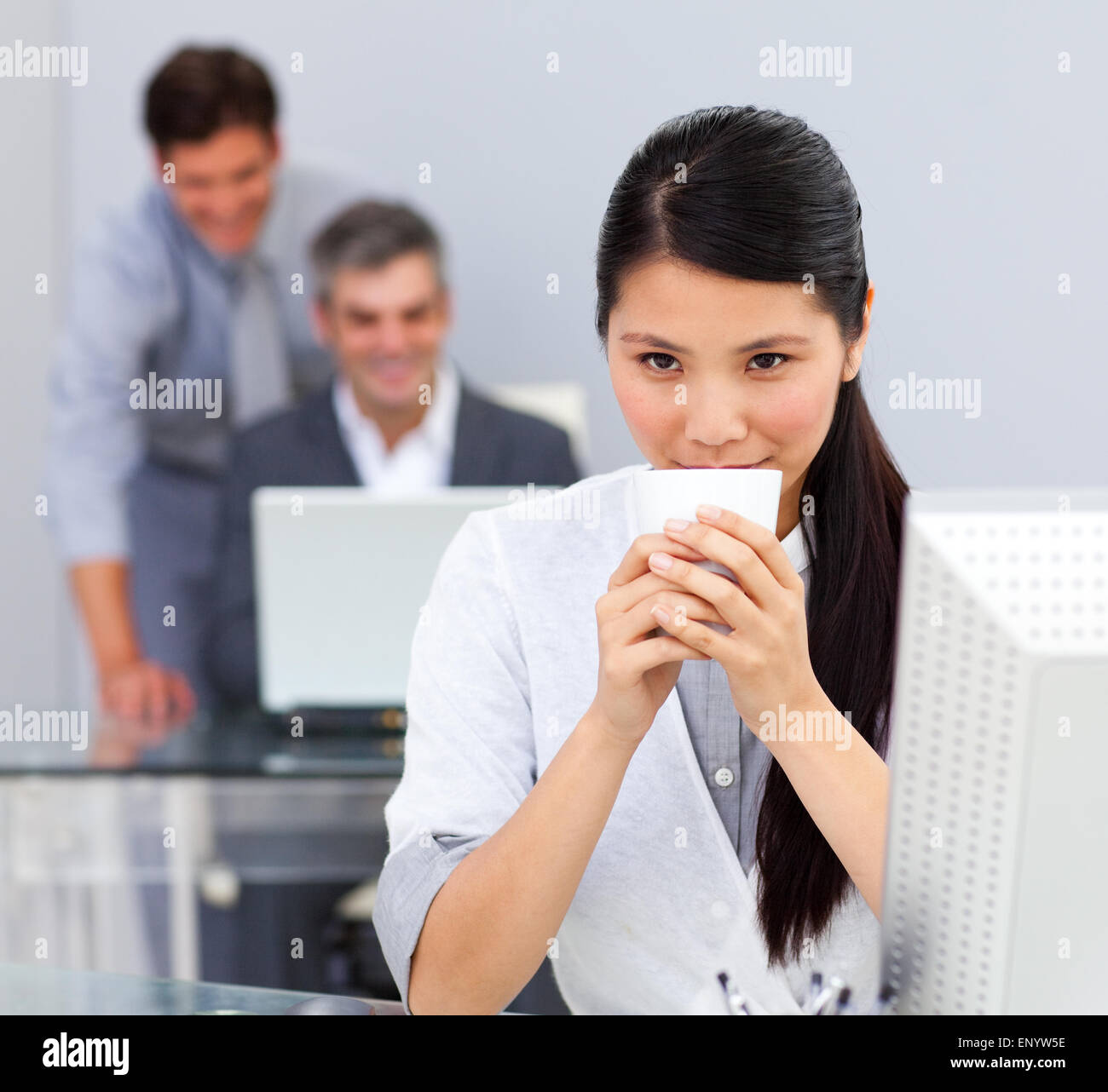 Brunette woman drinking coffee in the office Stock Photo - Alamy