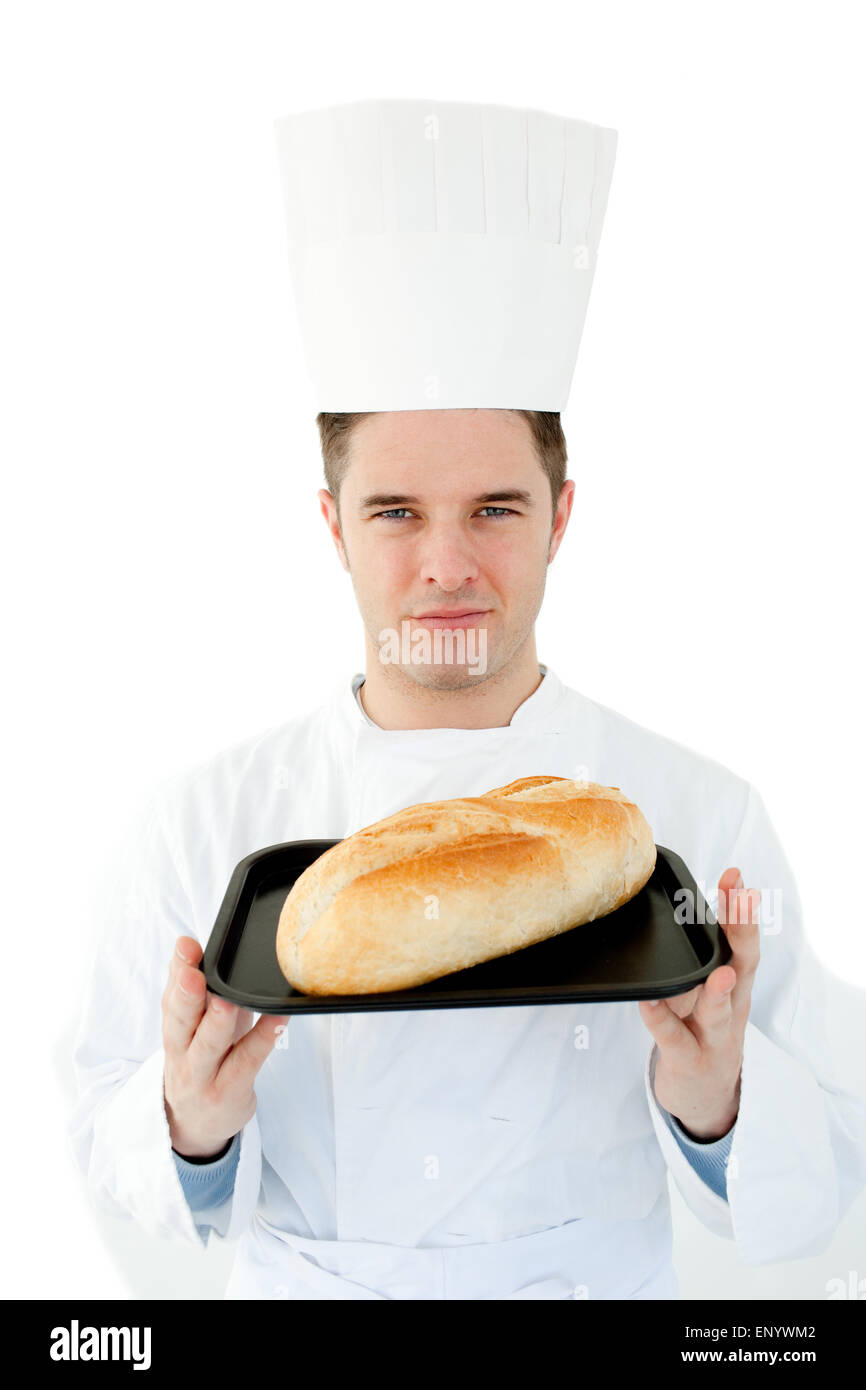 A male cook holding bread looking at the camera against white ...