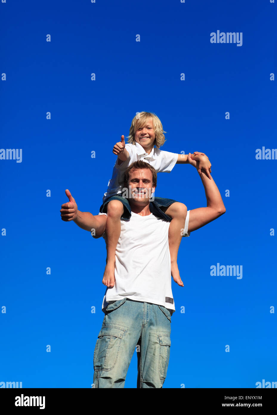Kid on man's shoulders with thumbs up Stock Photo - Alamy