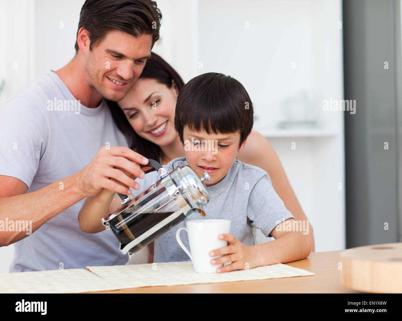 Happy family drinking coffee in the kitchen Stock Photo - Alamy