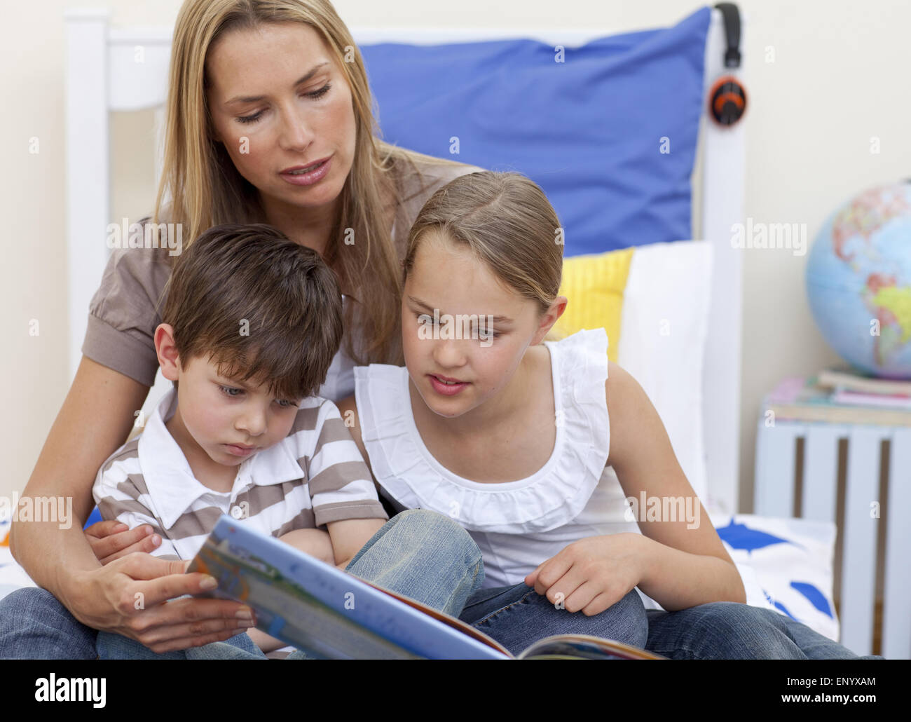 Mother reading a book with her children in bed Stock Photo - Alamy