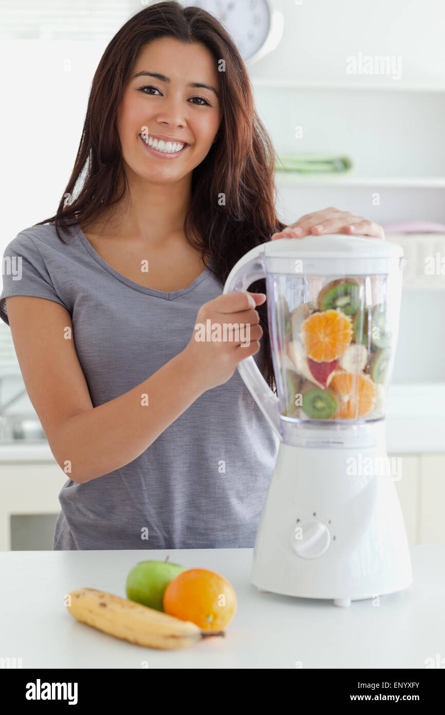 Good looking woman using a blender while standing Stock Photo - Alamy
