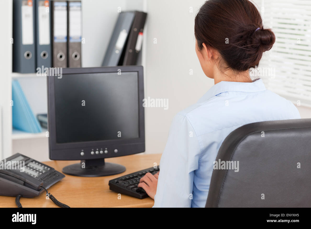 View from behind of a beautiful woman typing on a keyboard while ...