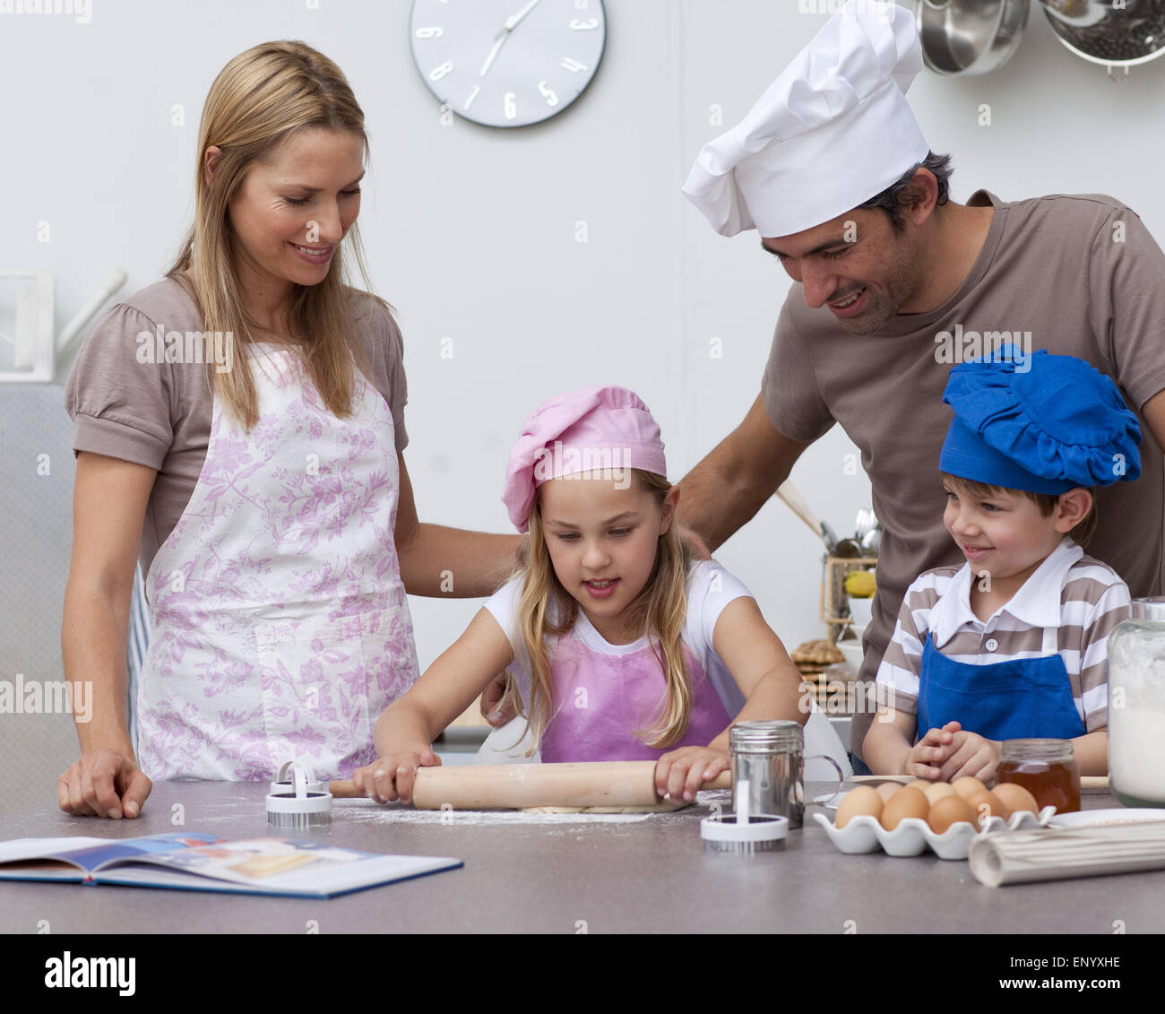 Parents helping children baking in the kitchen Stock Photo - Alamy