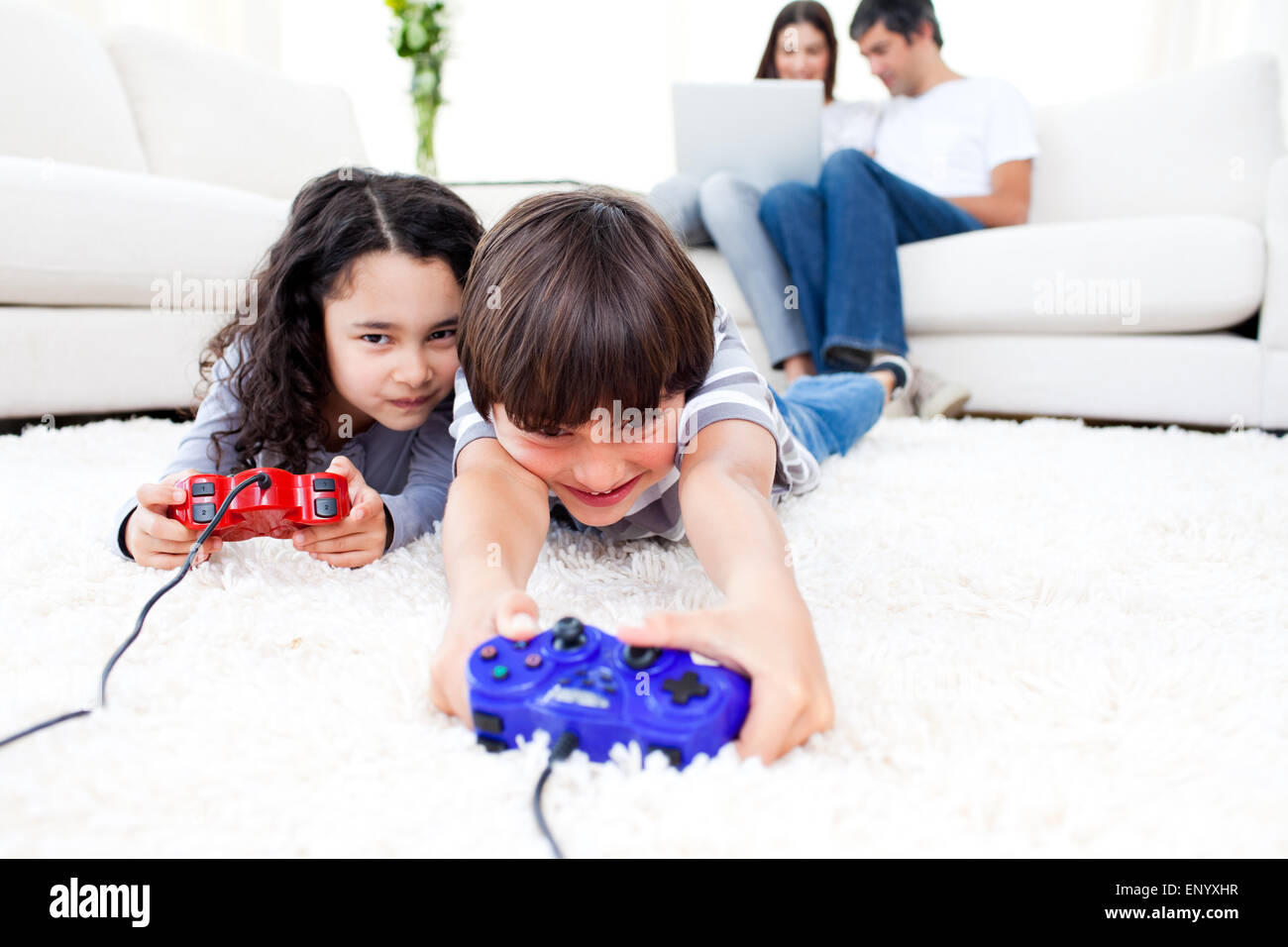 Excited children playing video games lying on the floor Stock Photo - Alamy