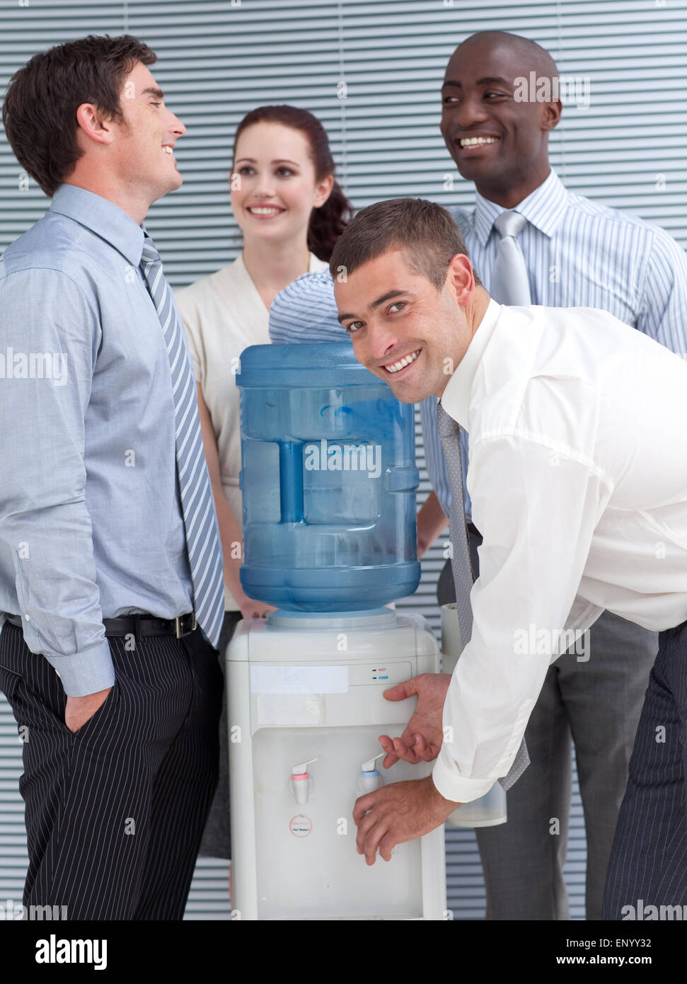 Colleagues standing by water cooler hi-res stock photography and images ...