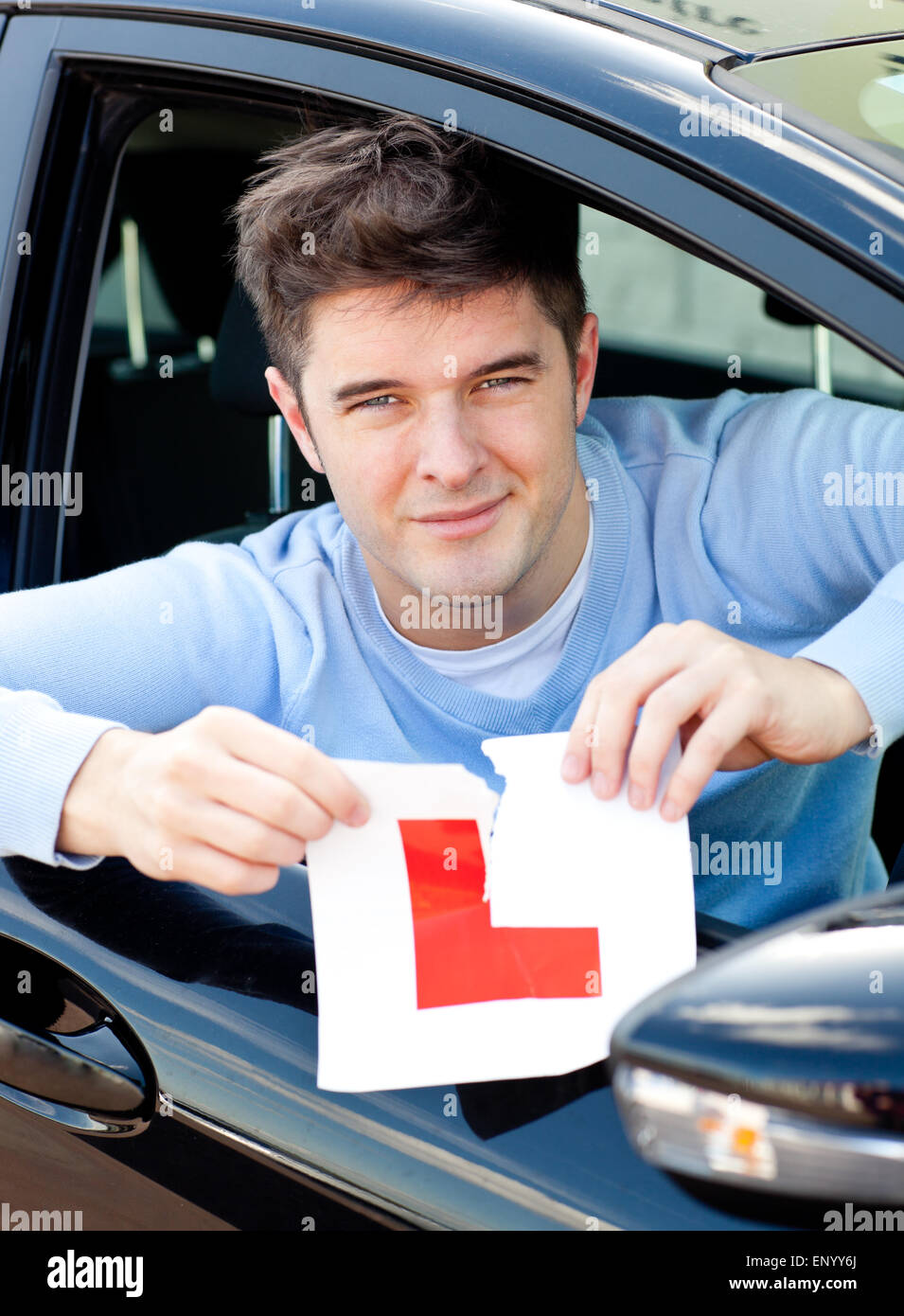 Happy young male driver tearing up his L sign Stock Photo - Alamy
