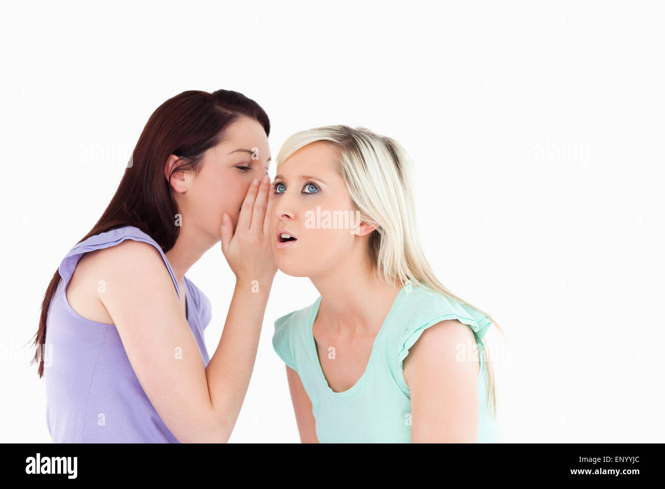 Portrait of a cute woman telling her friend a secret Stock Photo - Alamy